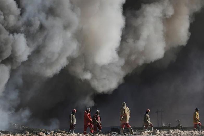 Risking flames and mines, Iraq oil workers battle to cap burning wells